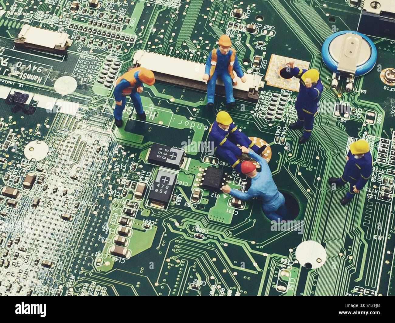 Mini engineer team are working on motherboard Stock Photo - Alamy