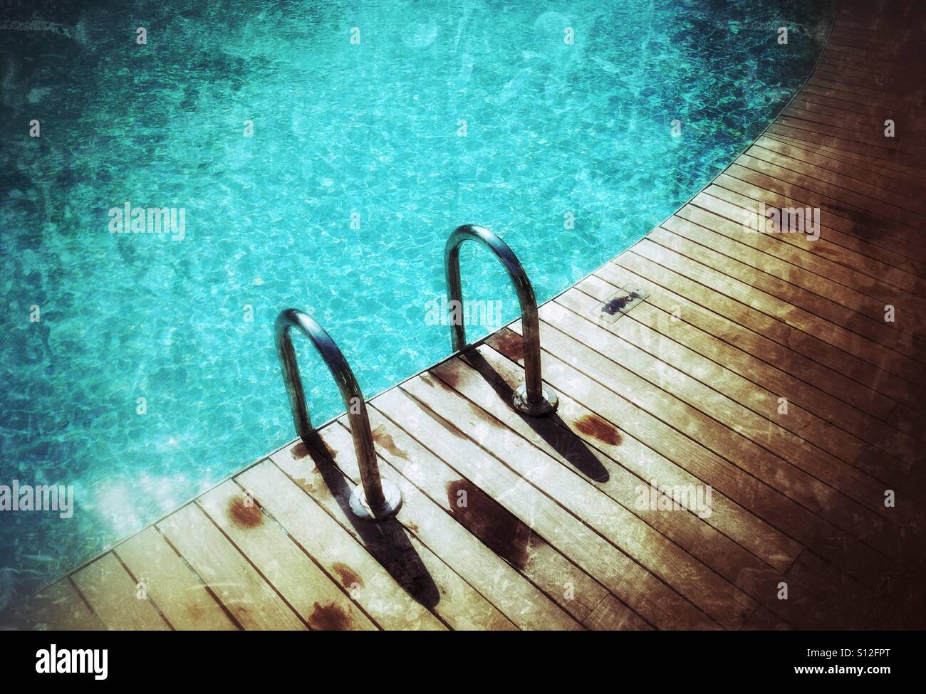 Swimming Pool with Chrome Rung Steps surrounded by Wooden Decking Stock ...