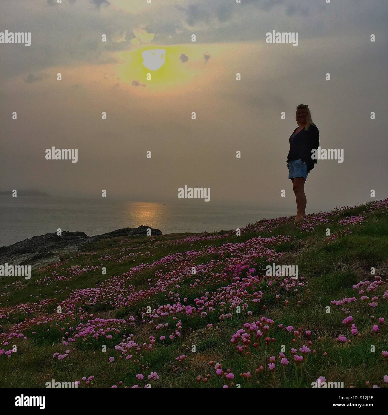 Woman on the cliff wife Stock Photo - Alamy