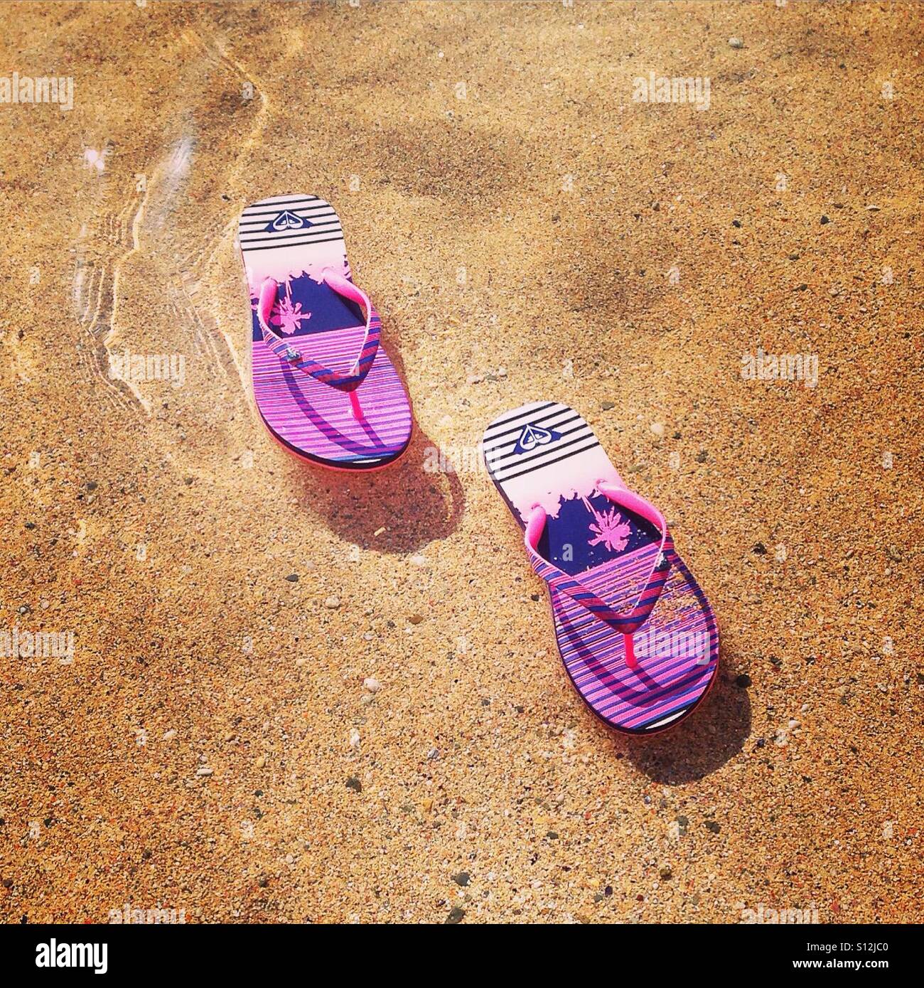 Roxy Flip-flops floating in the sea Stock Photo - Alamy
