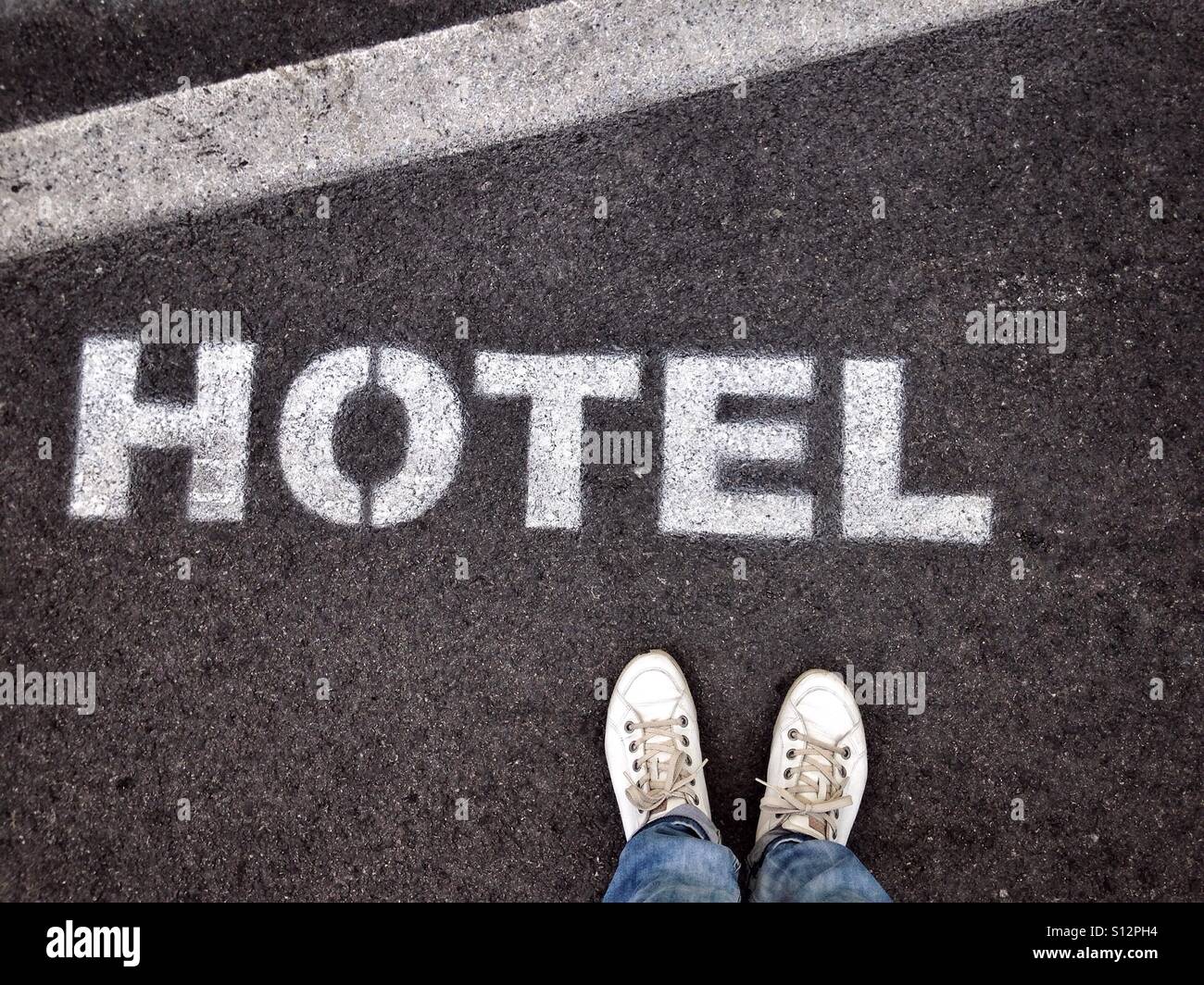 Legs standing at hotel sign on asphalt Stock Photo - Alamy