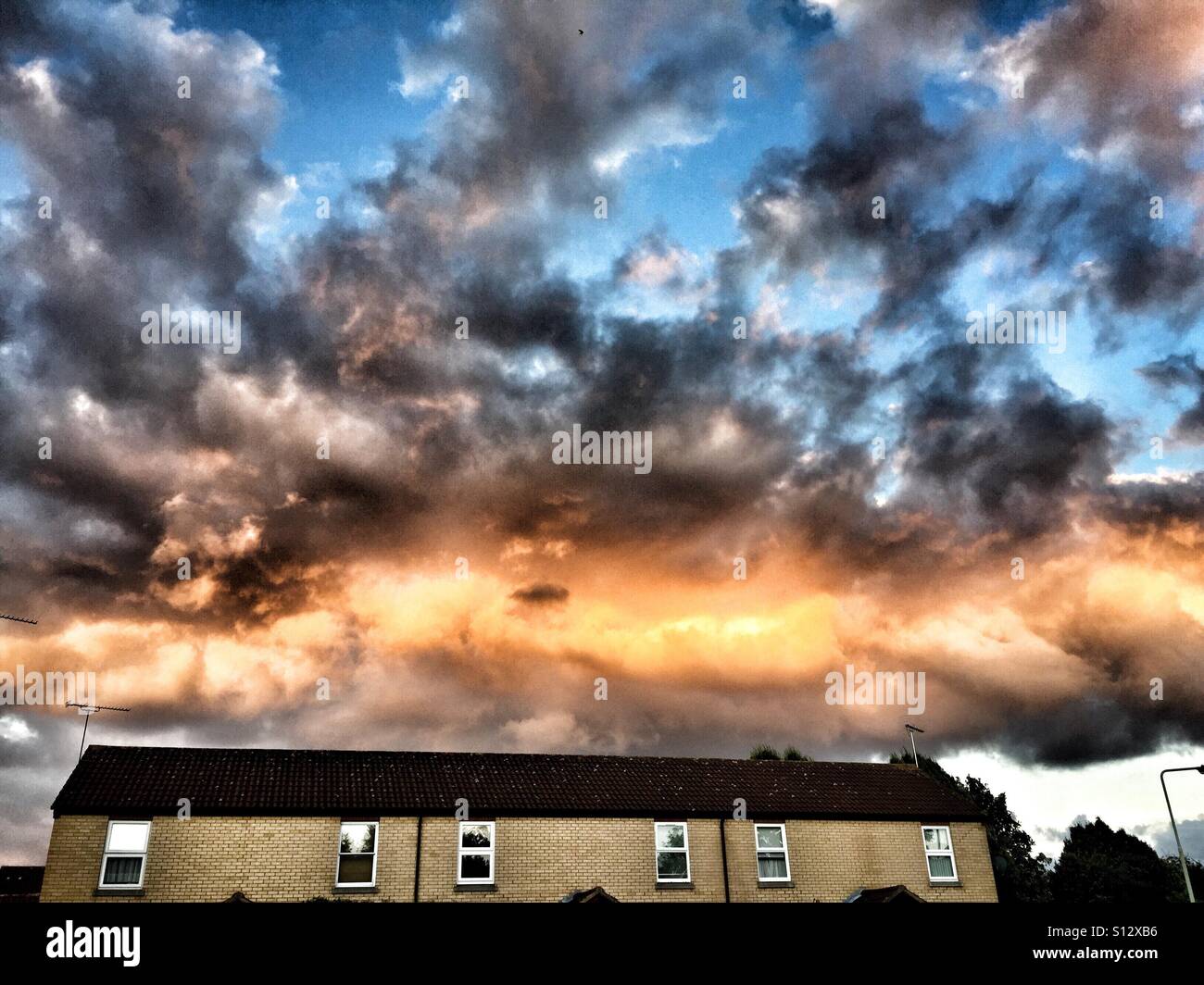 Sunset over houses Stock Photo - Alamy