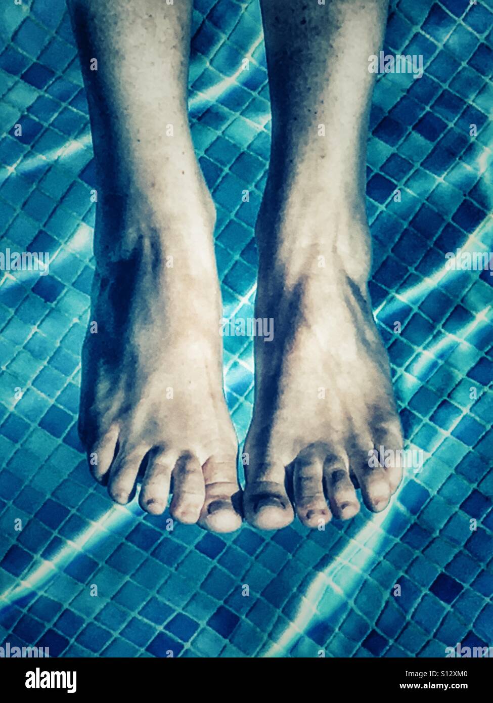 Feet in swimming pool Stock Photo - Alamy