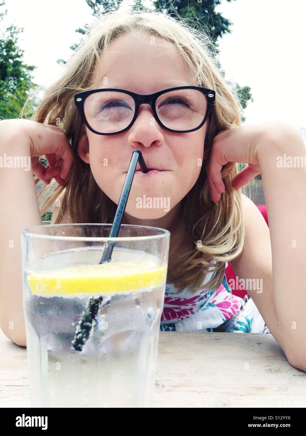 Sipping a drink of lemonade Stock Photo - Alamy