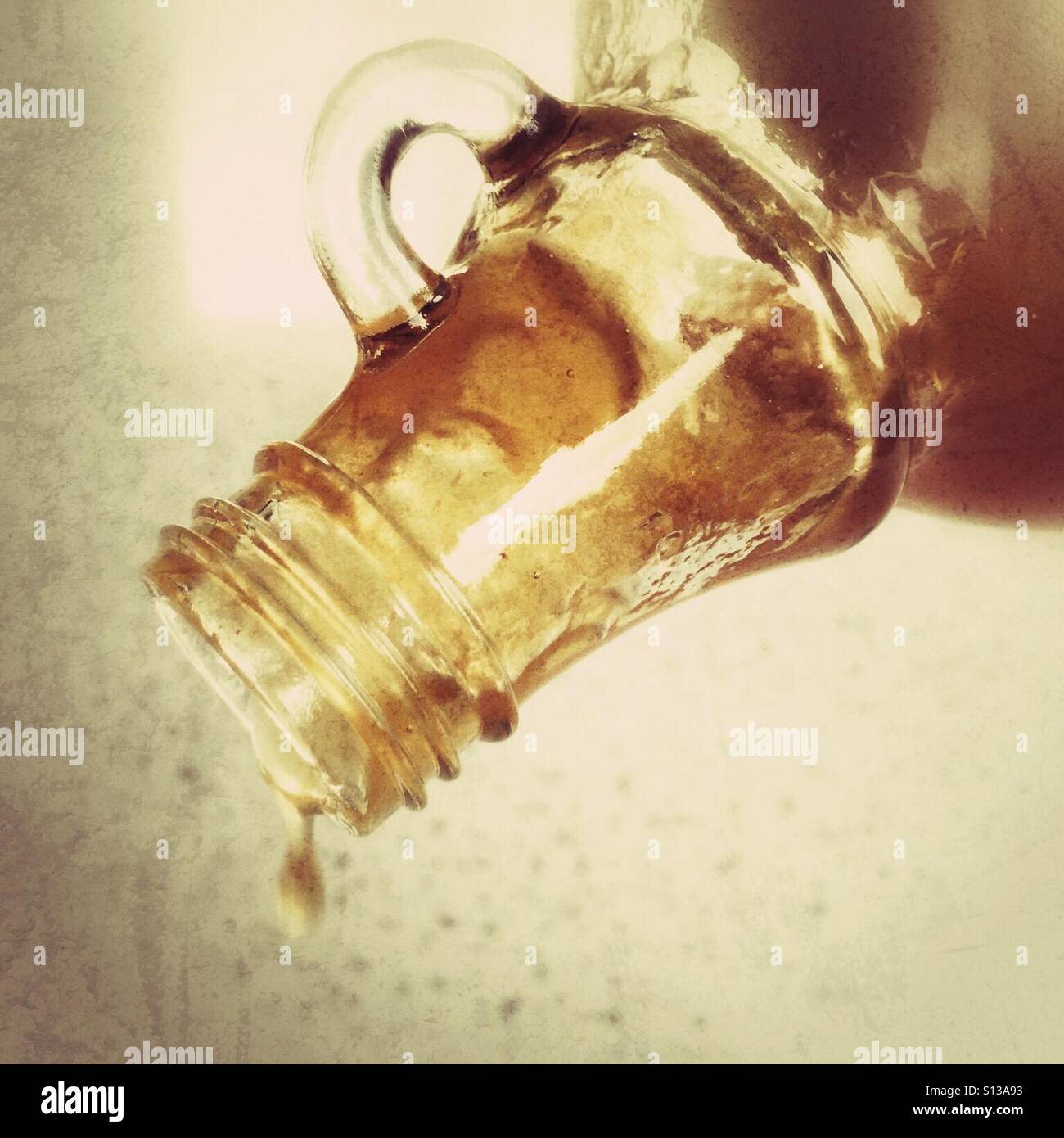 Syrup drips from the spout of a glass bottle Stock Photo - Alamy