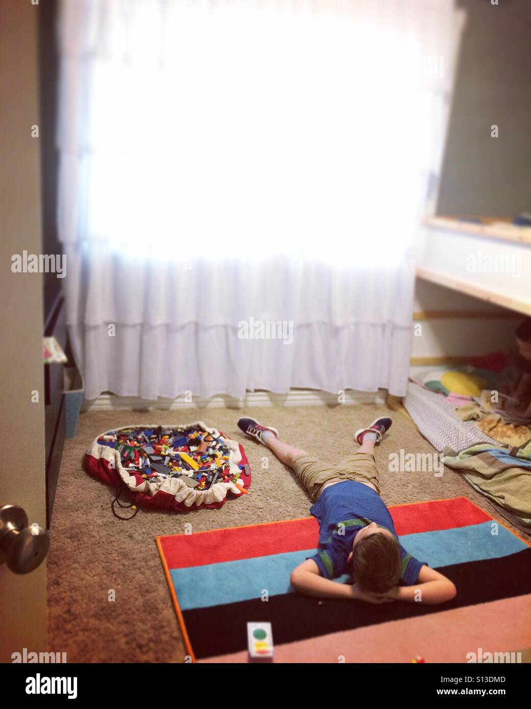 Boy lying on rug in hi-res stock photography and images - Alamy