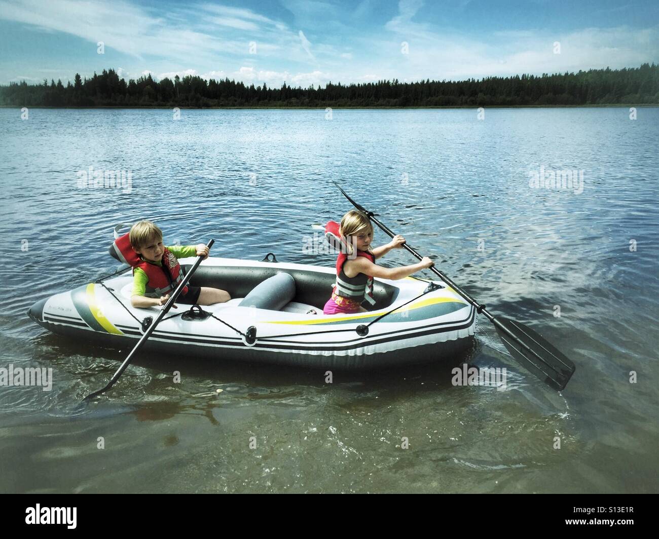 Children paddling a dinghy on a forest lake Stock Photo - Alamy