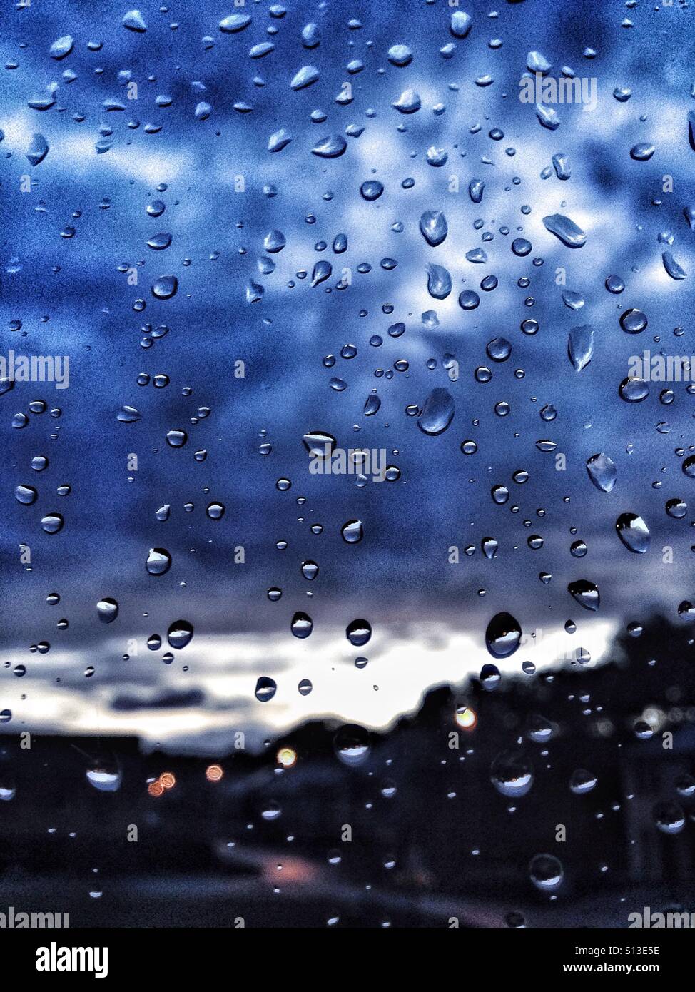 Raindrops on window with cloudy sunset Stock Photo - Alamy
