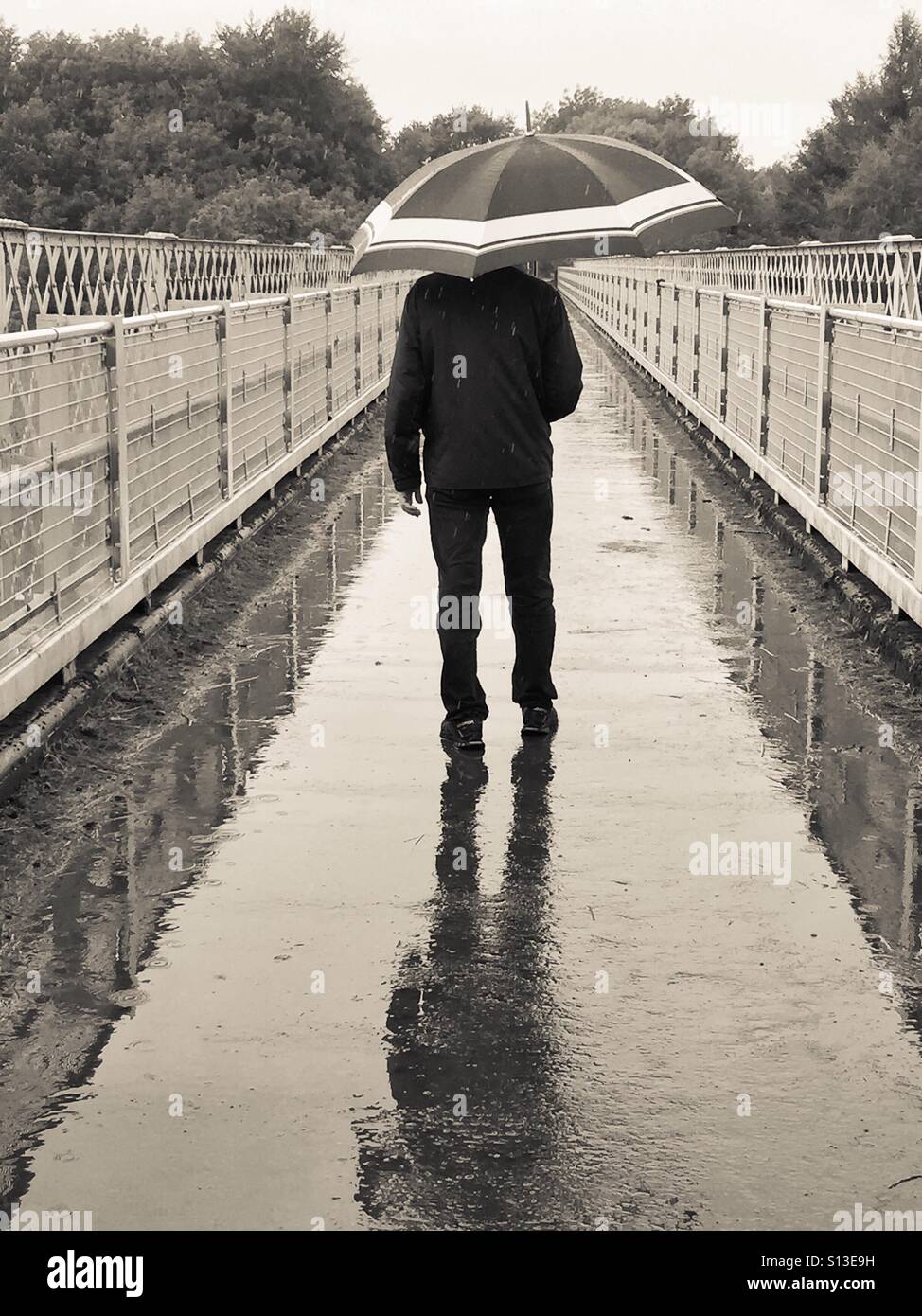 Old man walking rain hi-res stock photography and images - Alamy