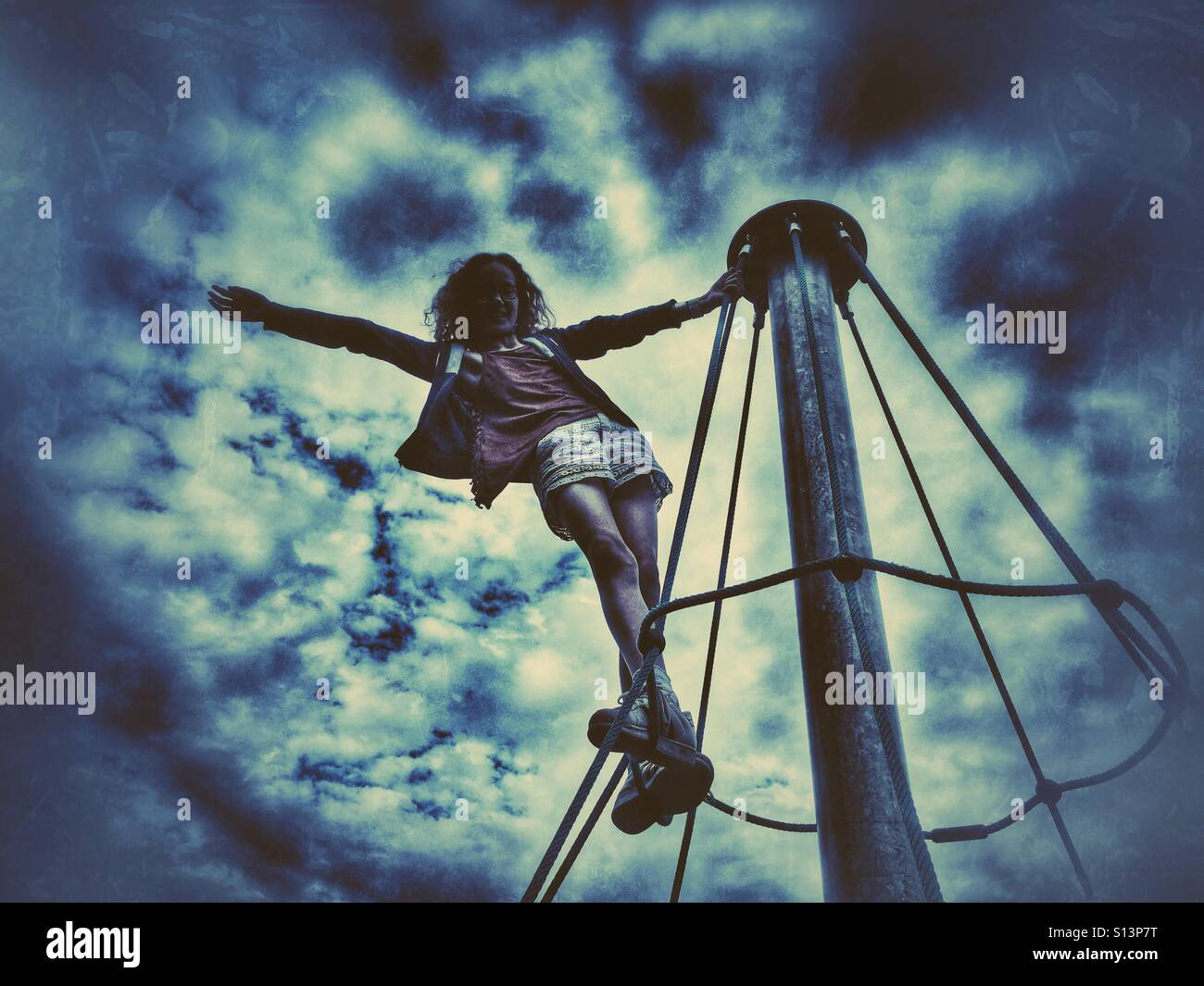 Young girl celebrating reaching the top of a rope climbing frame Stock ...