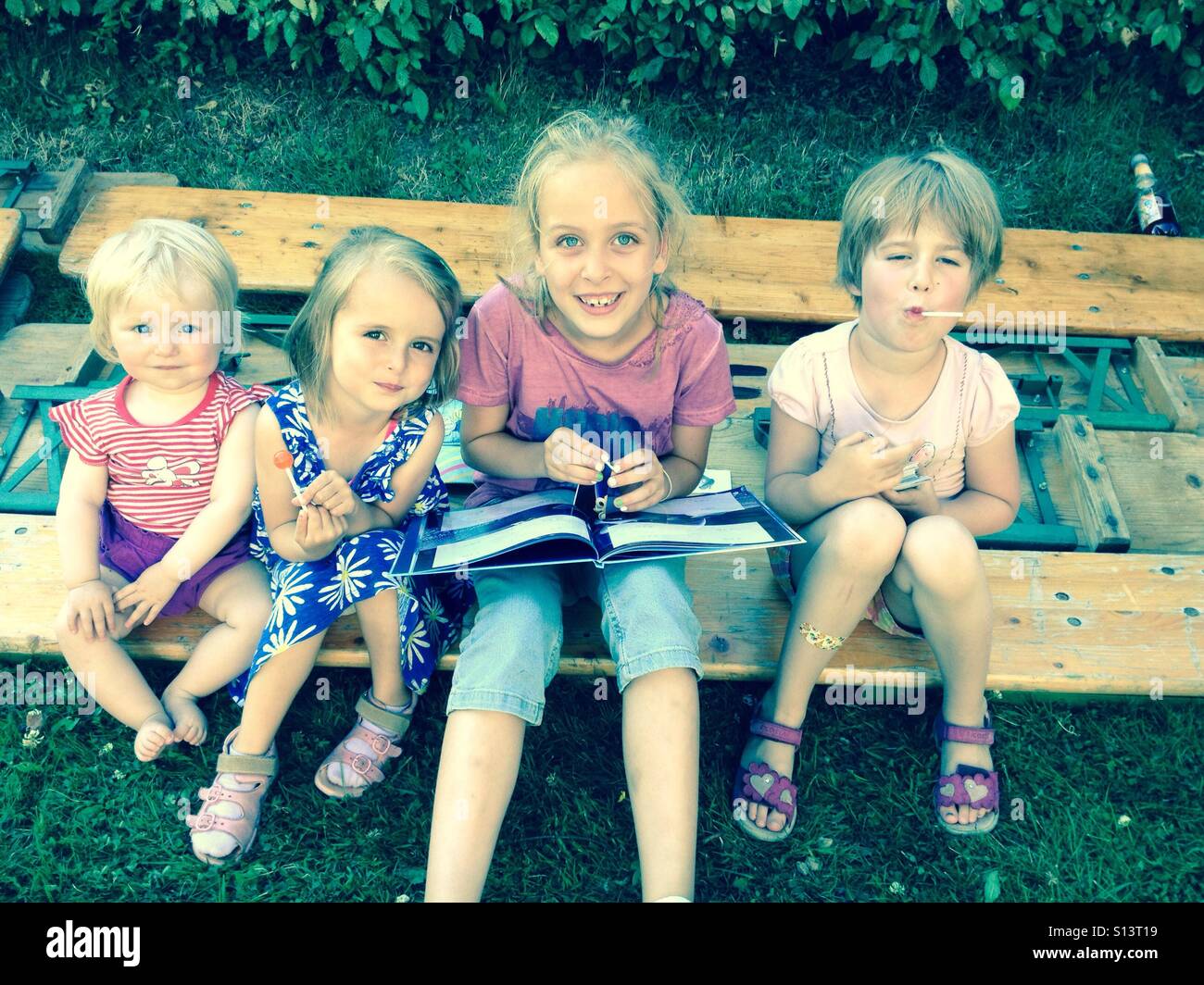 Four girls on a bench having some fun time Stock Photo - Alamy