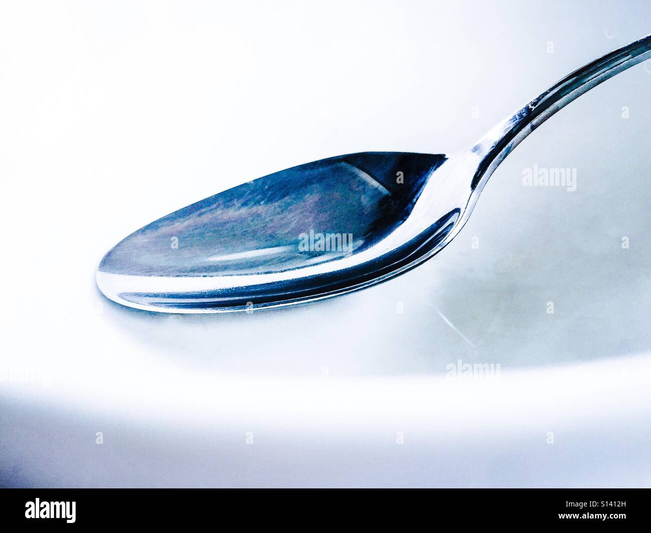 A spoon rests inside an empty bowl Stock Photo - Alamy