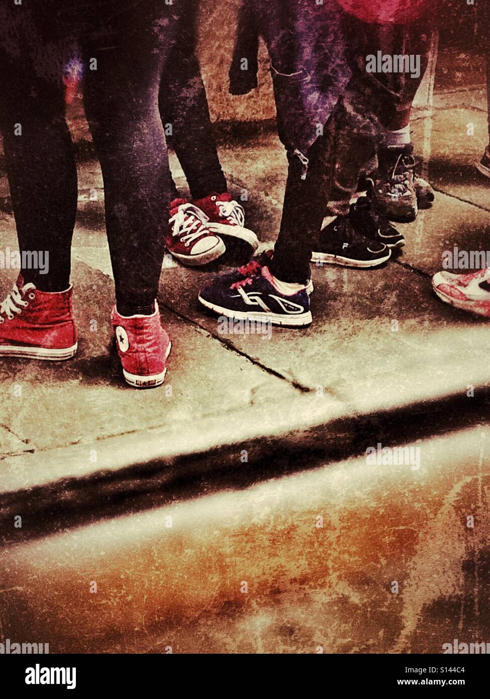 Young people stood on pavement England UK Stock Photo - Alamy
