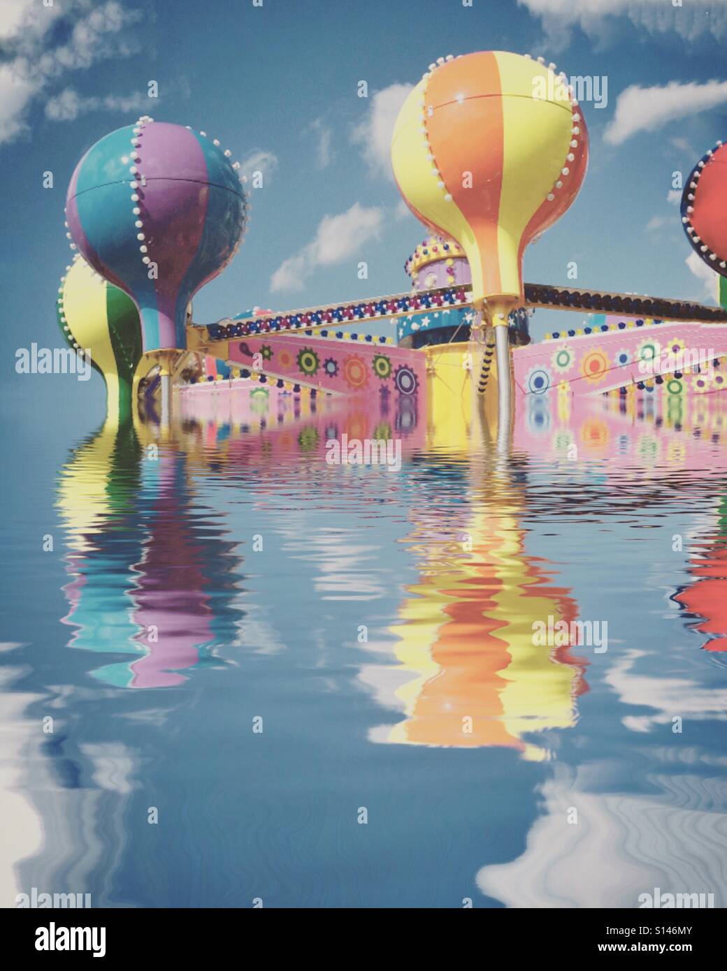 An abstract image of balloons on a carnival ride rising out of water ...