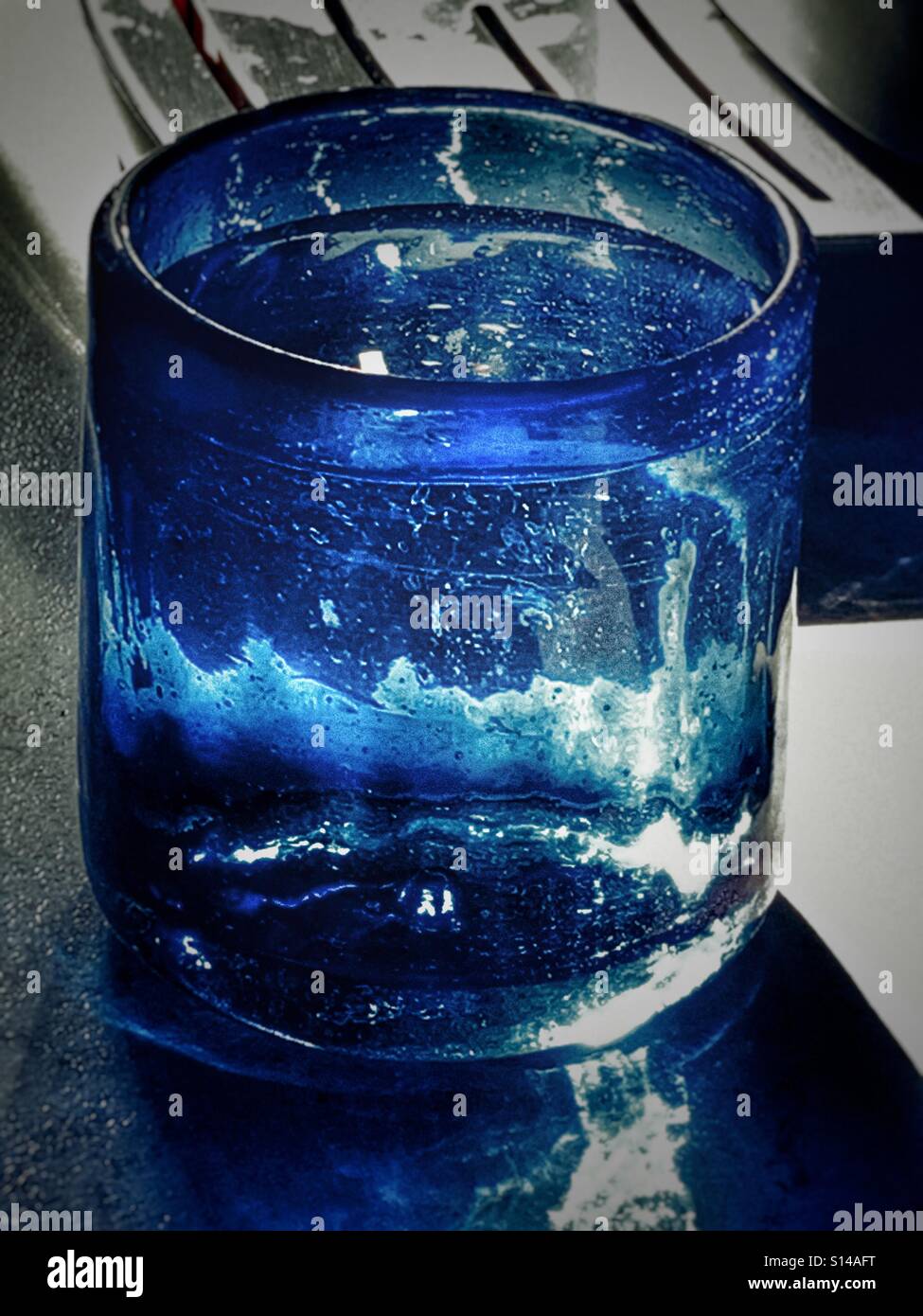 Water in a blue glass. Backlit Stock Photo - Alamy