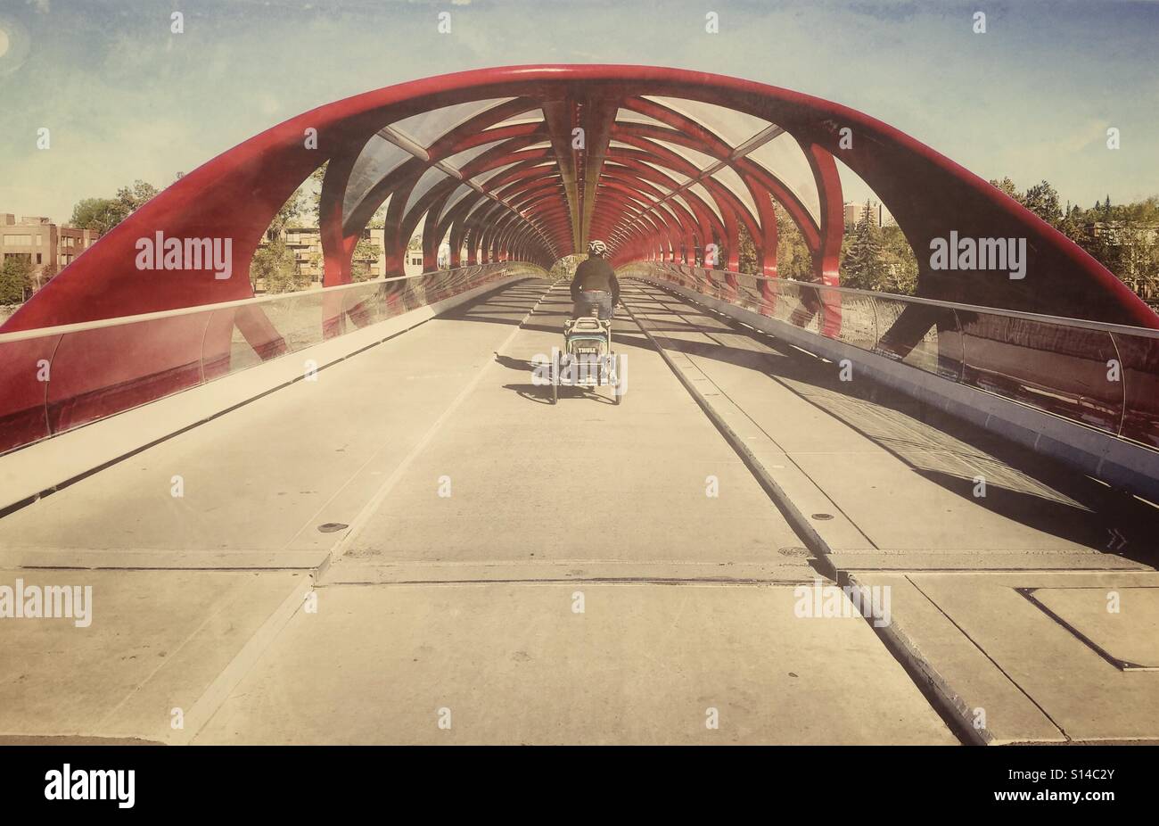 A cyclist with a bike trailer uses the designated cycle path on the Peace Bridge in Calgary ...