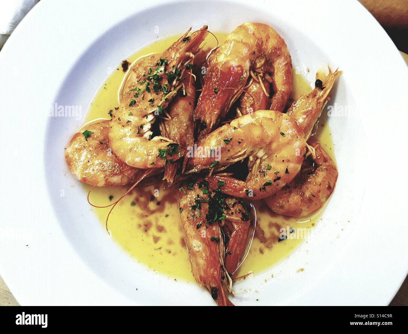 Crevettes in garlic butter with parsley Stock Photo - Alamy