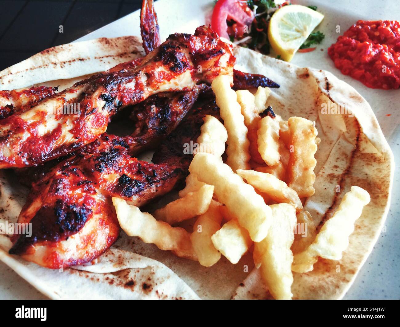 Arabian cuisine grilled chicken wings served with traditional sauce and ...