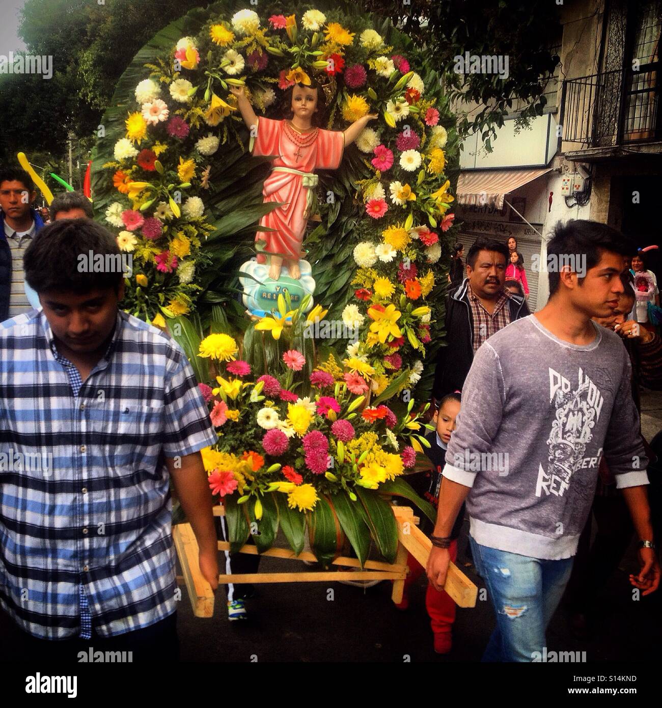 Mexicans carry an image of Baby Jesus decorated with flowers during a ...