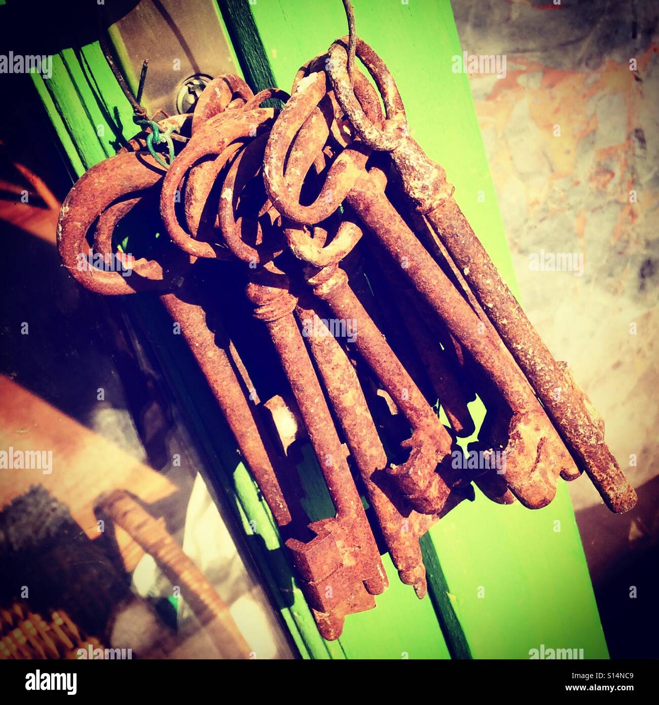 Large bunch of old rusty keys hanging on a green door Stock Photo - Alamy