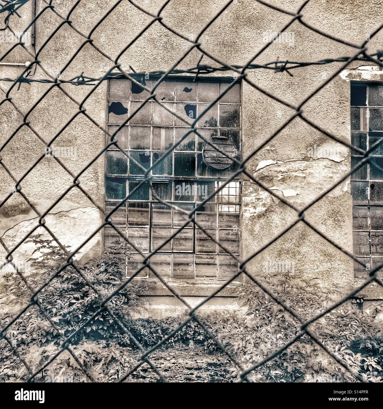 Broken windows behind a fence Stock Photo - Alamy