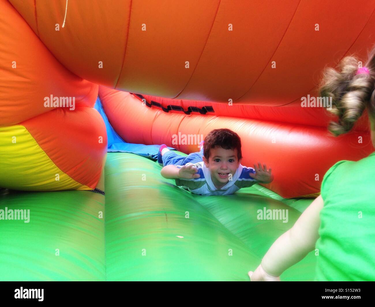 Two kids playing inside inflatables Stock Photo - Alamy