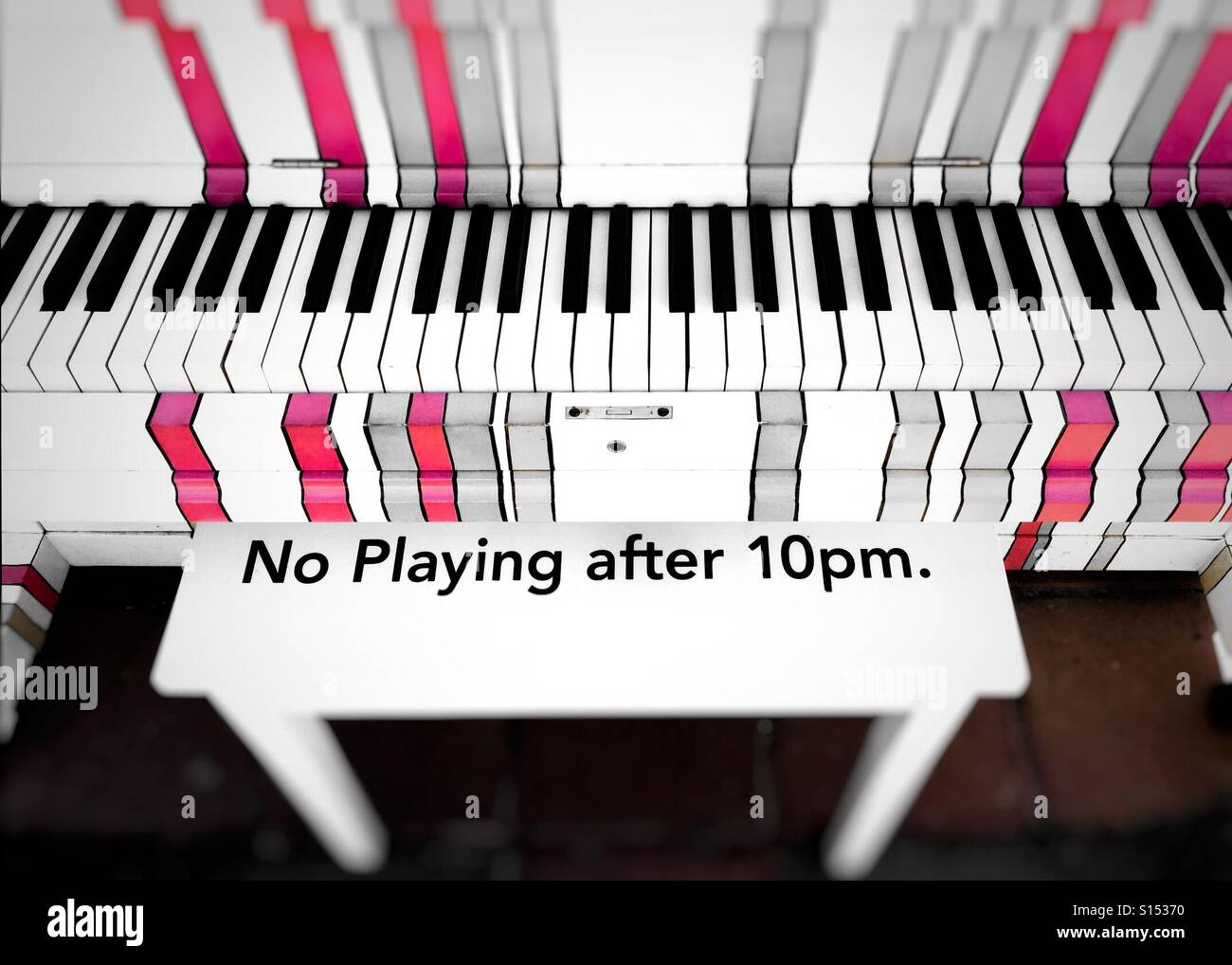 A public piano with a sign on the bench limiting late-night playing ...