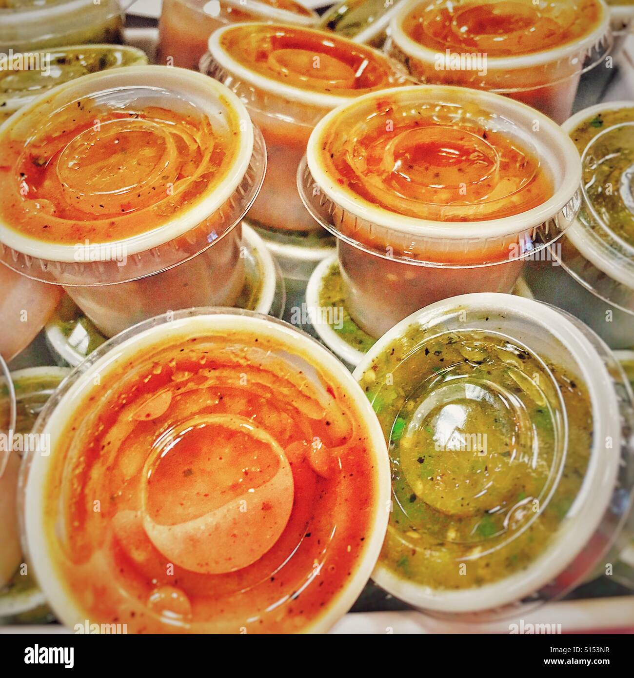 Green and red salsa in plastic cups Stock Photo - Alamy