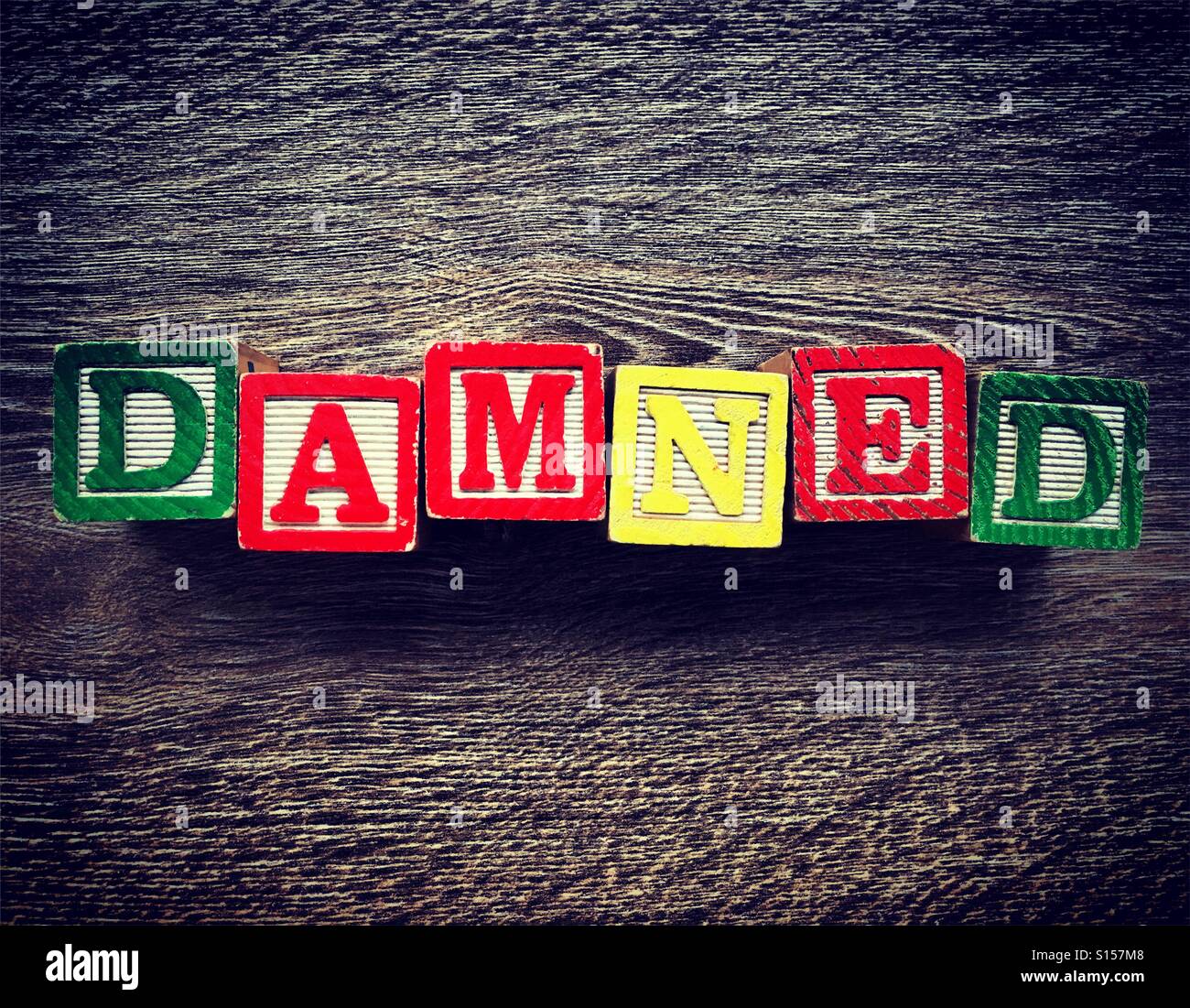 DAMNED word written with wood block letter toys Stock Photo - Alamy