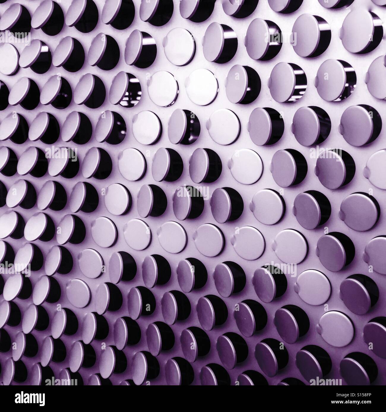 A capital letter A pressed into round metal tabs angled to create ...