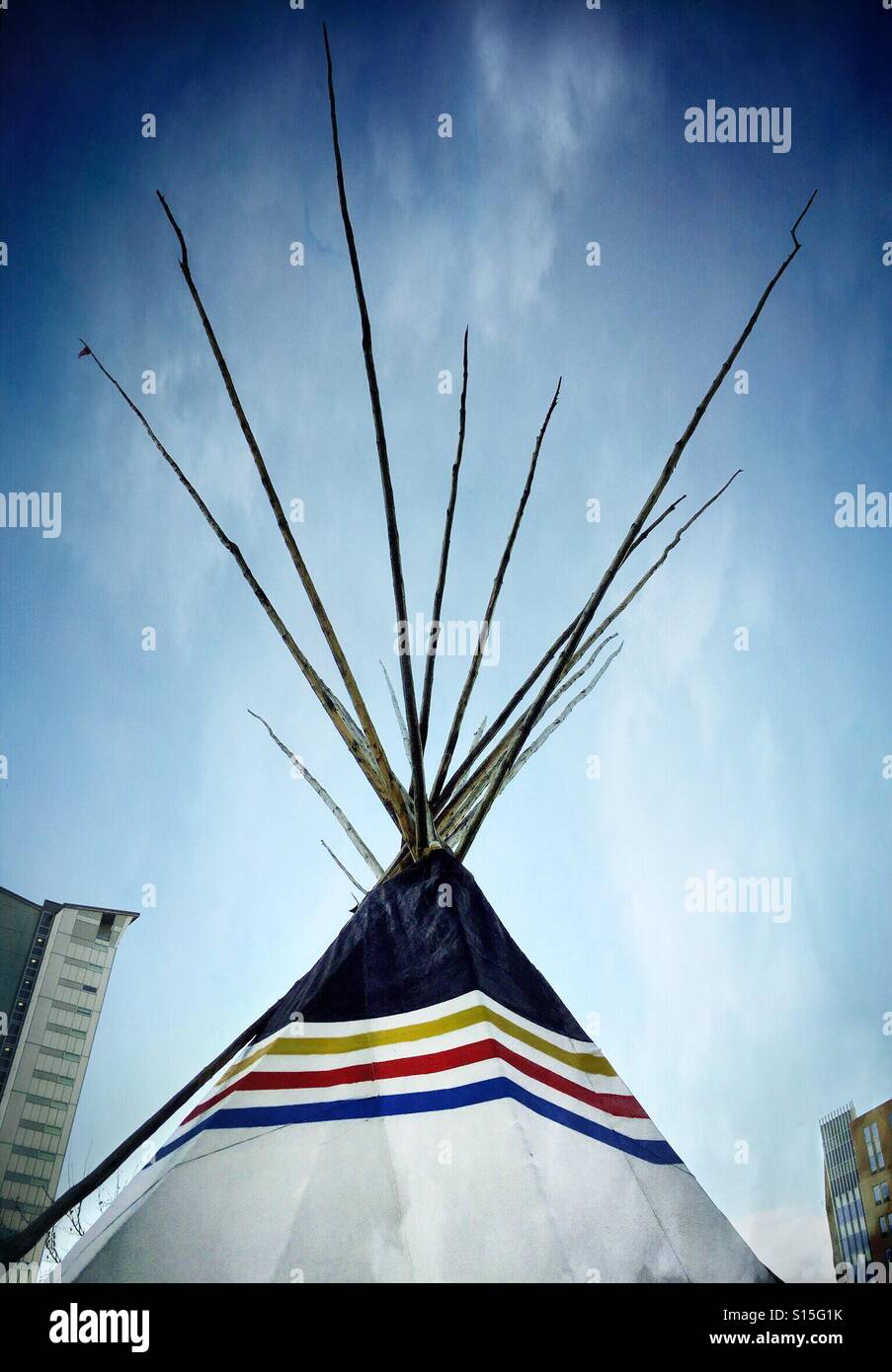 A traditional First Nations teepee stands among modern skyscrapers ...