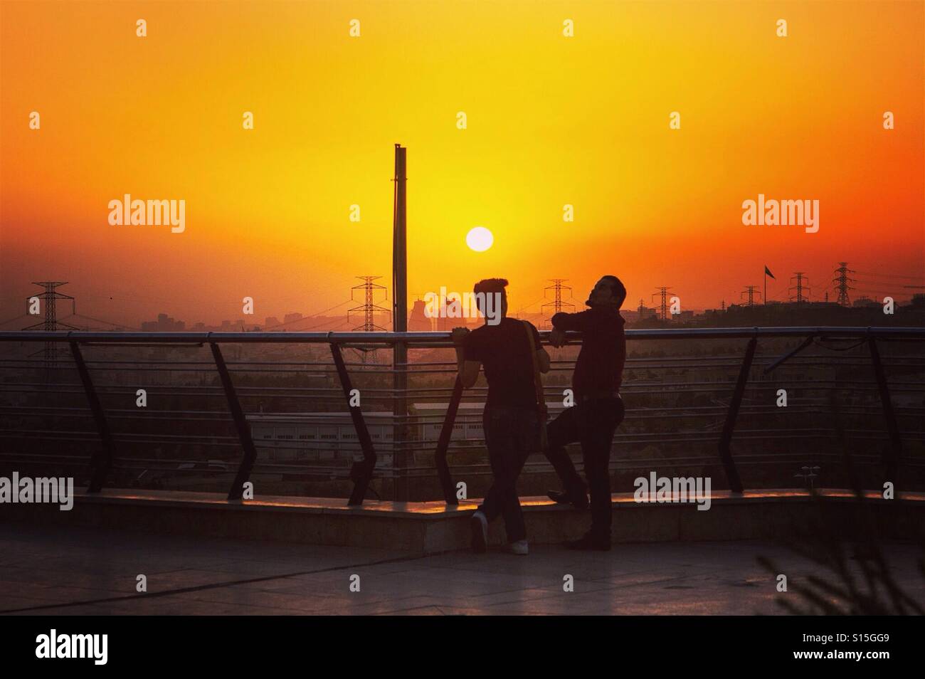 Two men talking at sunset Stock Photo - Alamy