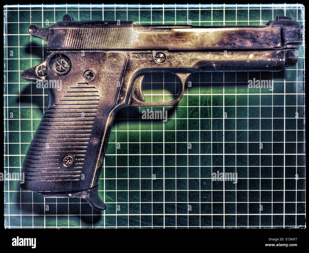 Handgun on grid background Stock Photo - Alamy