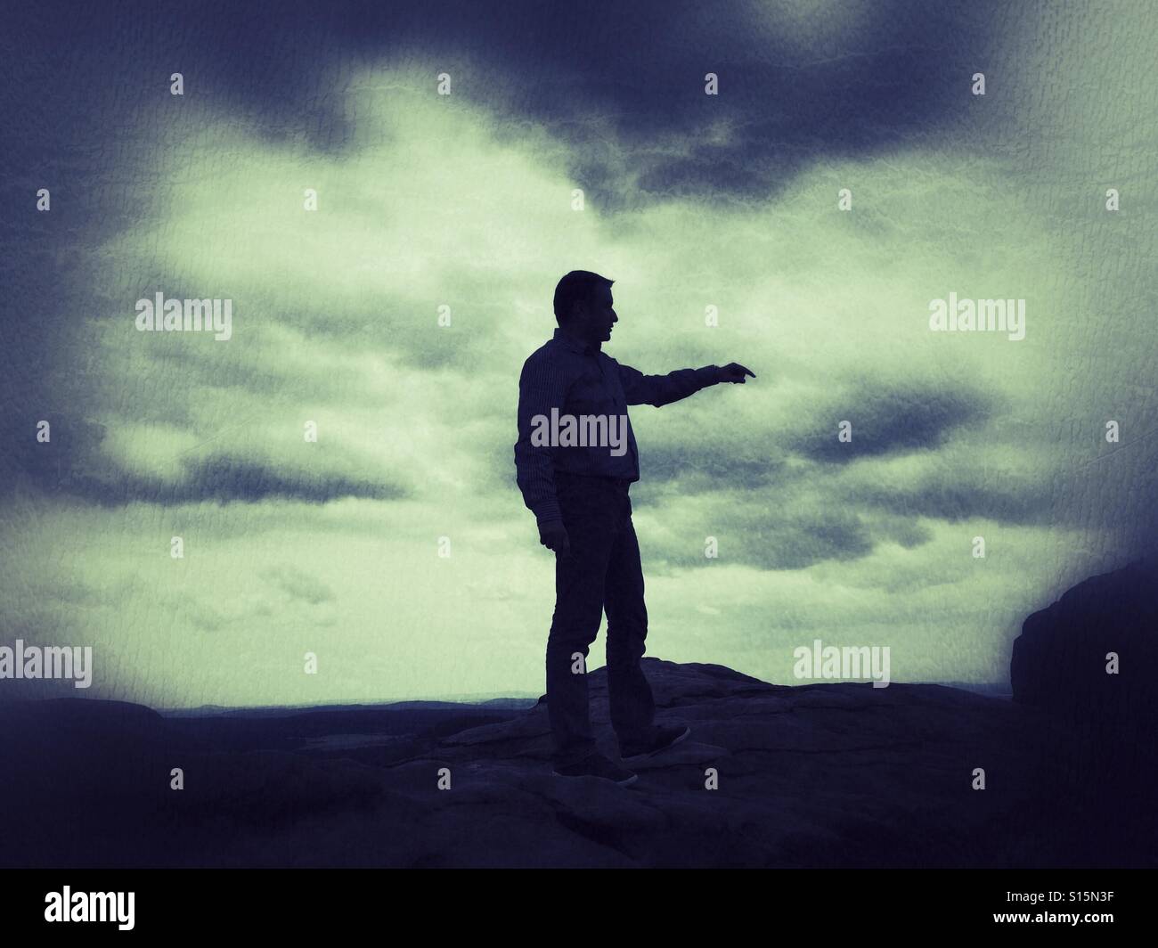 Man on the peak pointing his hand Stock Photo - Alamy