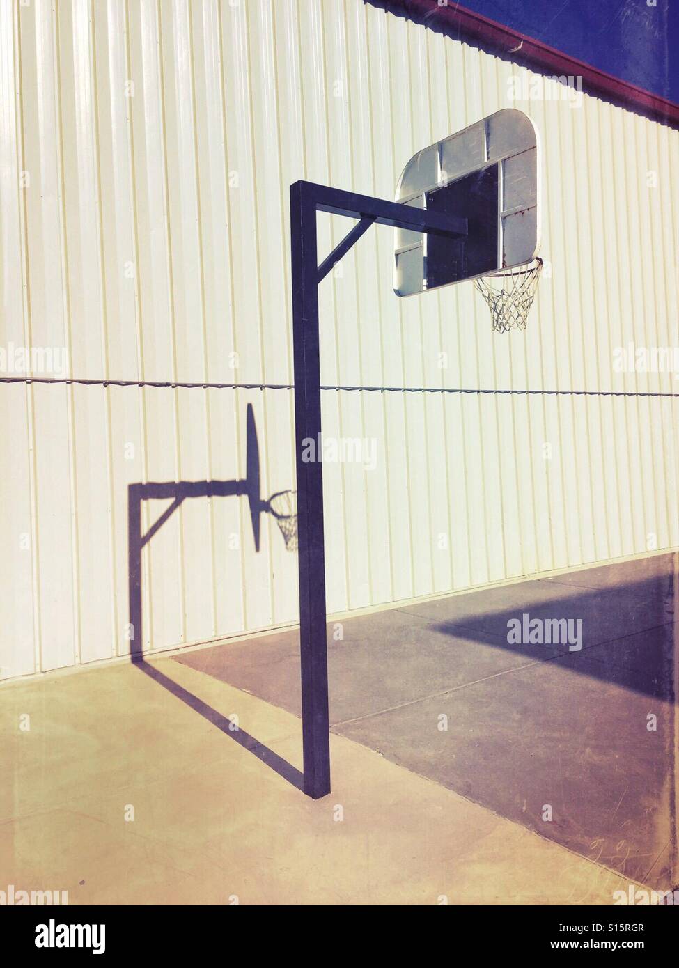 A basketball net with its shadow against a building clad in steel Stock ...