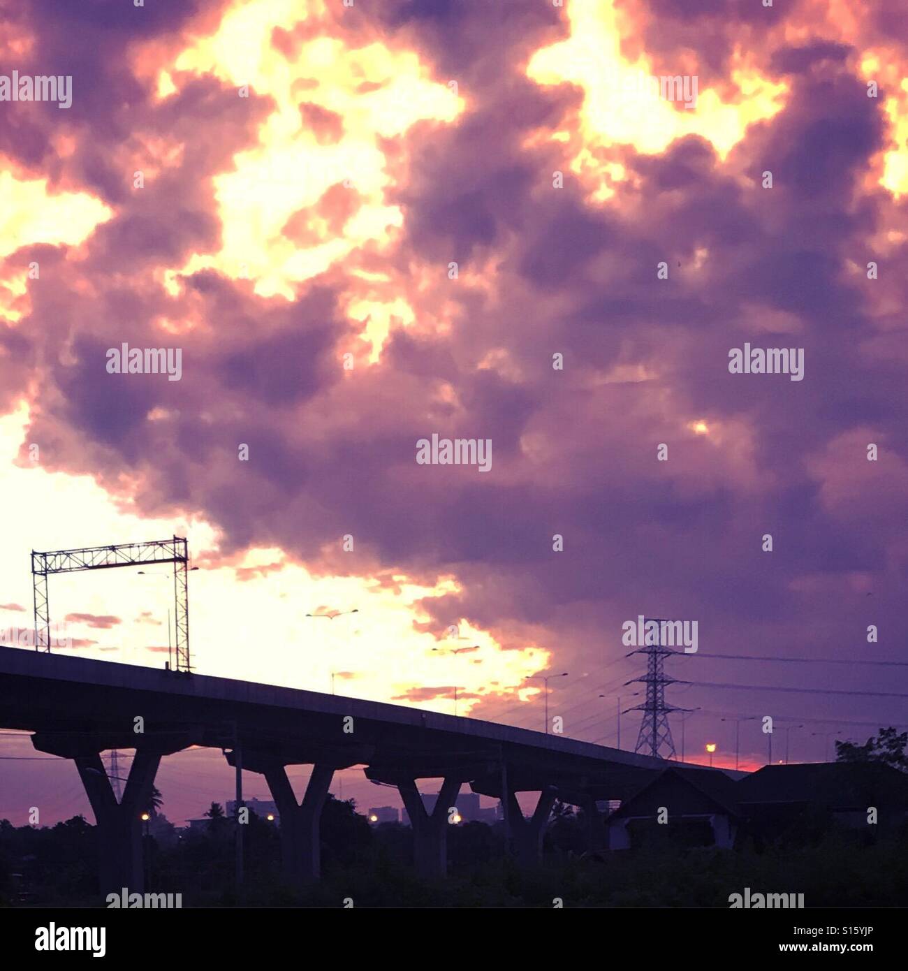 Golden & Purple sky with enormous clouds over the bridge Stock Photo ...