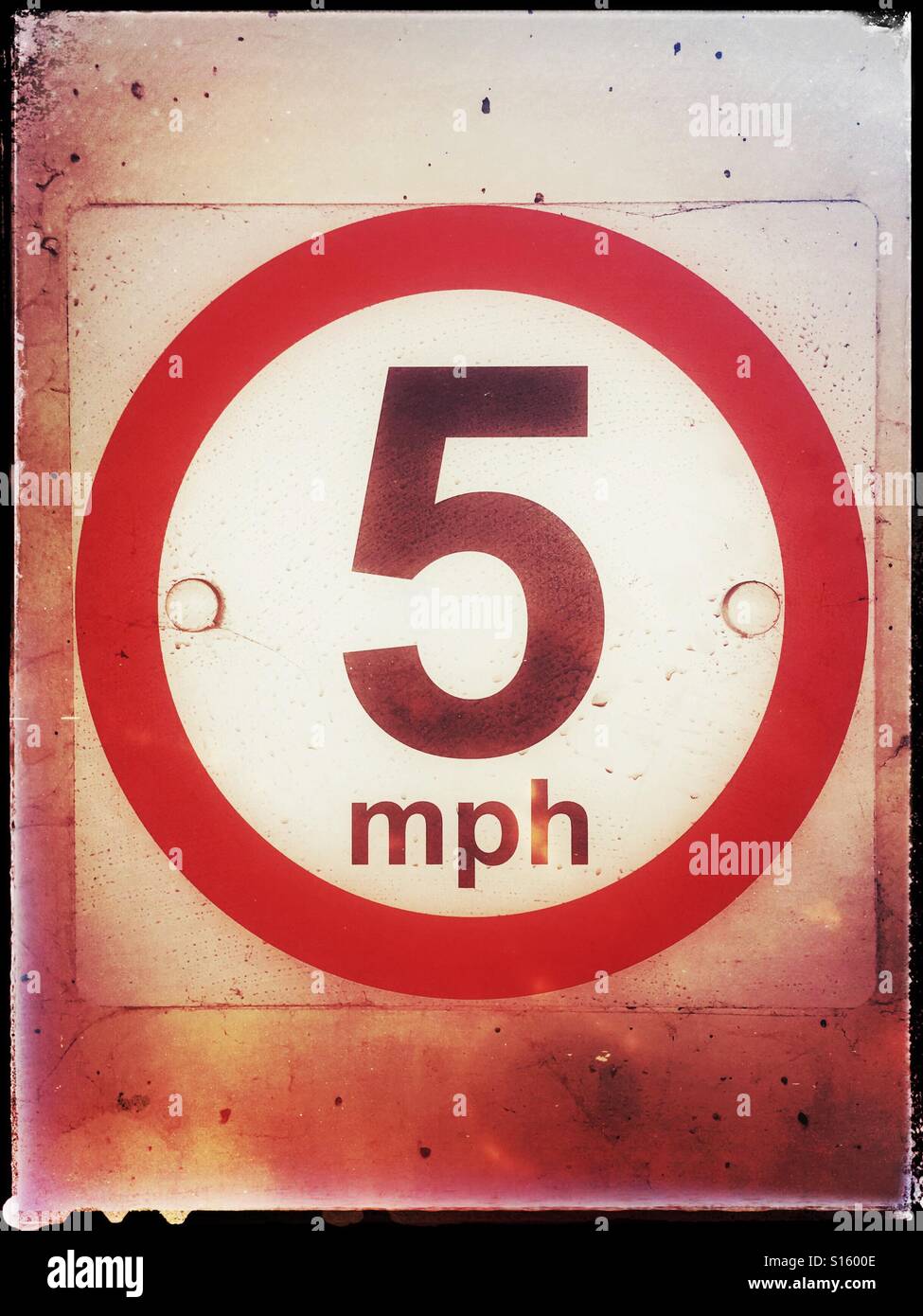 A 5 Miles Per Hour advisory sign attached to the wall of a multi-story ...