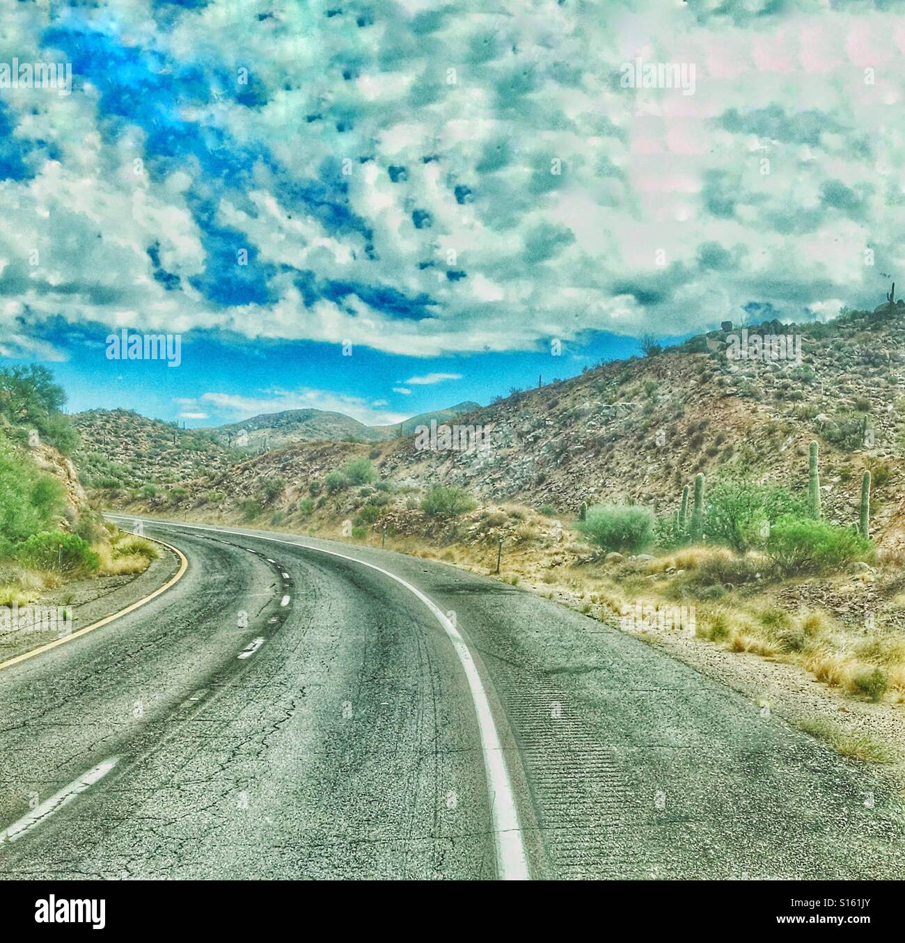 Empty road with a left hand turn Stock Photo - Alamy