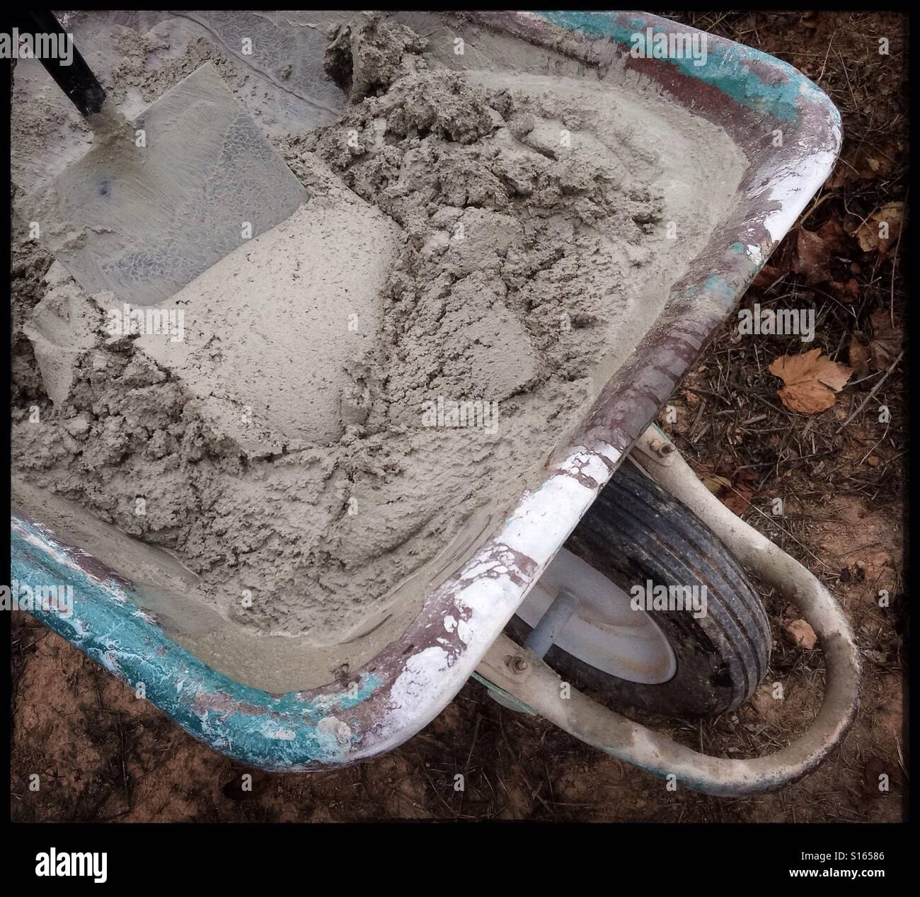 A wheelbarrow of cement mortar with a spade Stock Photo - Alamy
