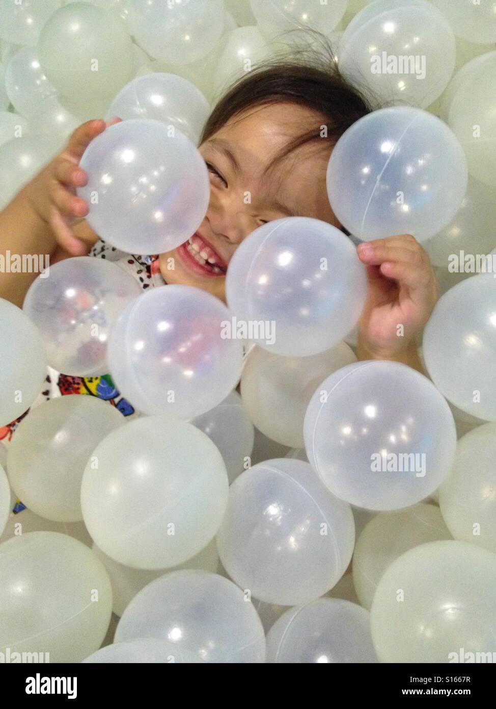 Happy Kid Under Balls Stock Photo - Alamy