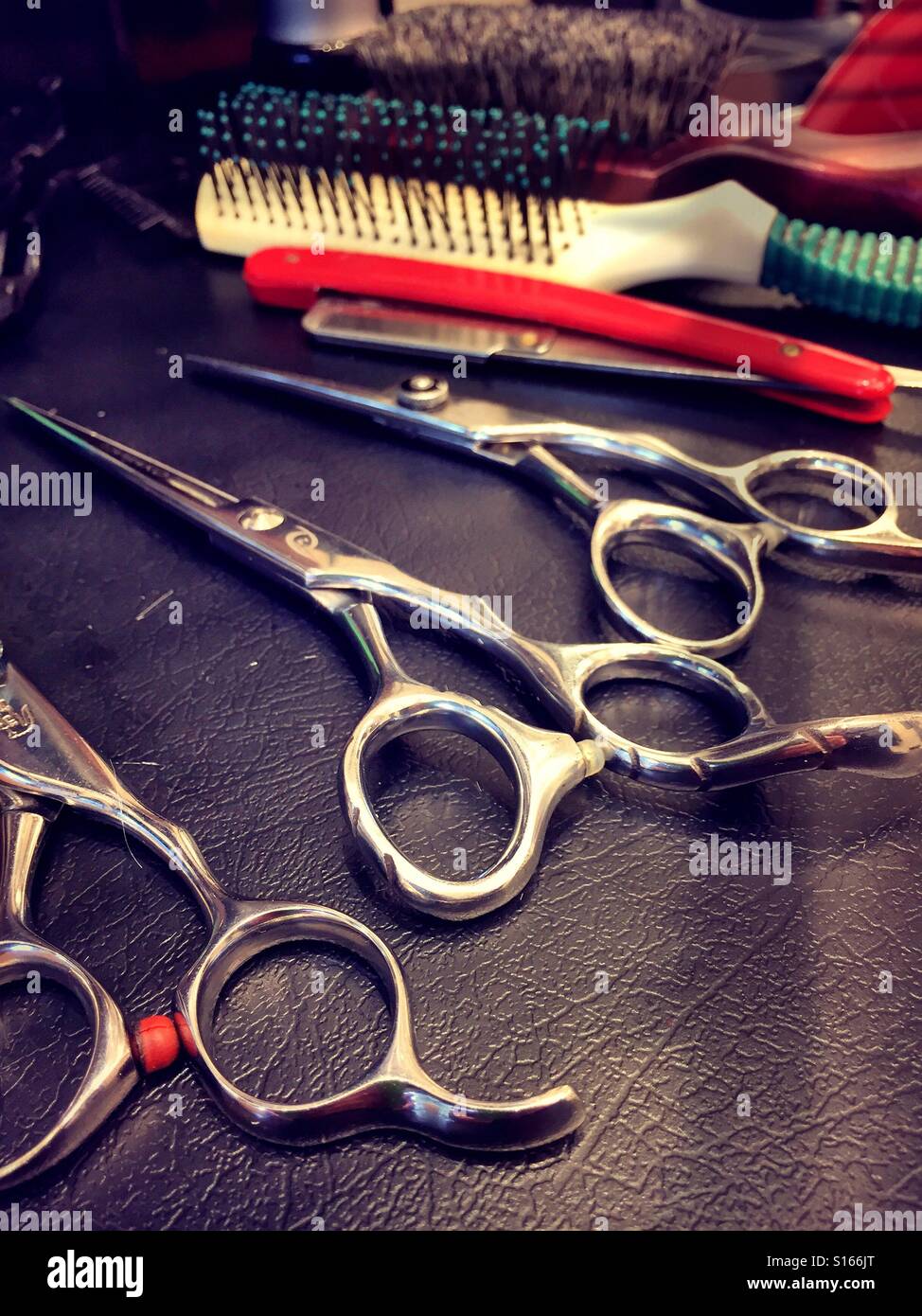 Barber shop detail of professional scissors, straight razor and brushes ...