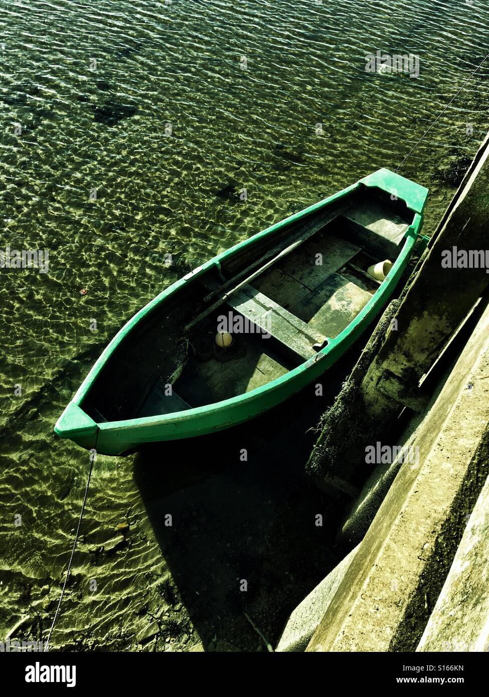 Green boat on a green sea moored at the quayside Stock Photo - Alamy