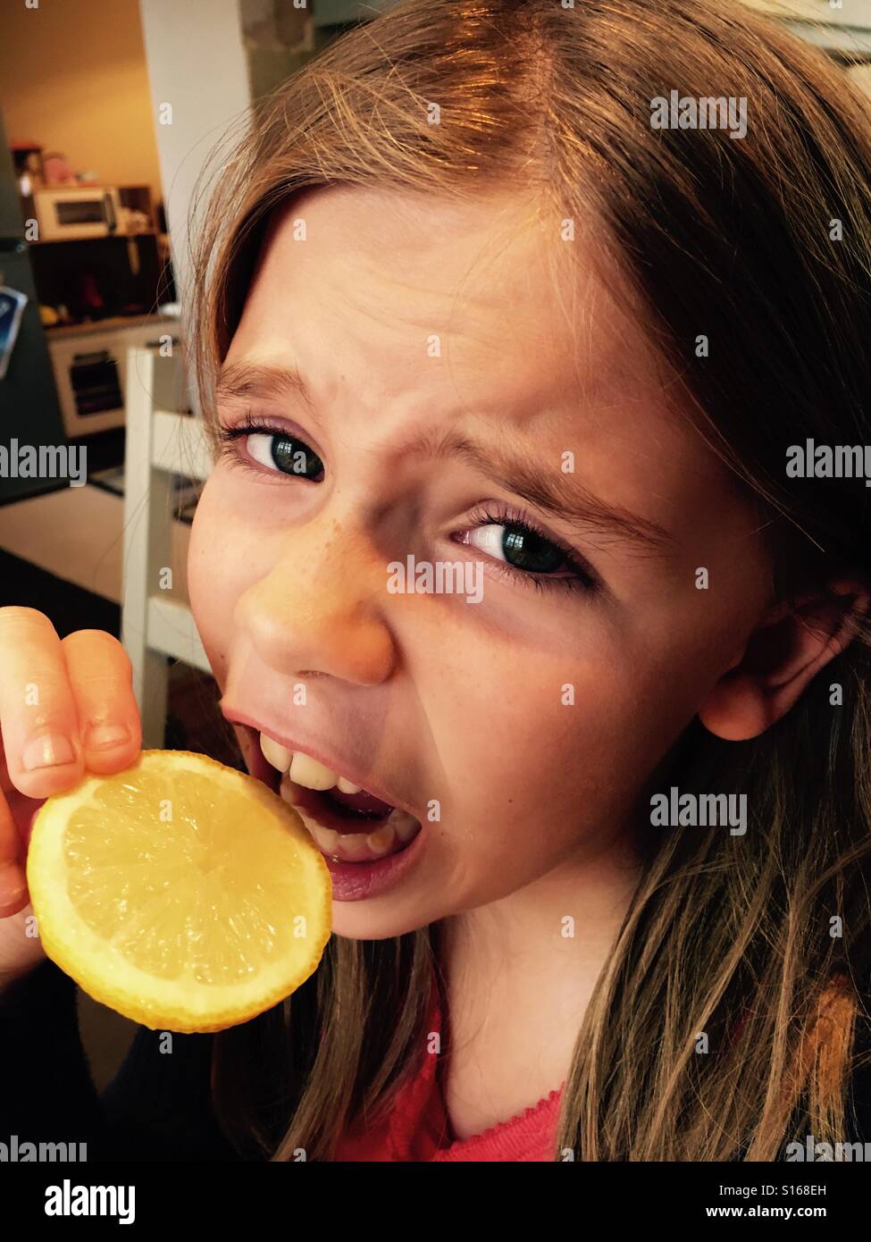 Tasting a lemon slice Stock Photo - Alamy