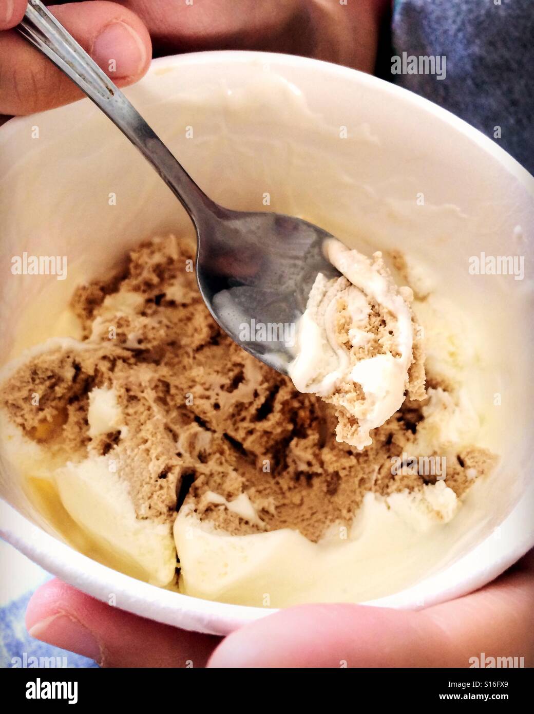 Person with teaspoon taking ice cream from cup of ice cream Stock Photo ...