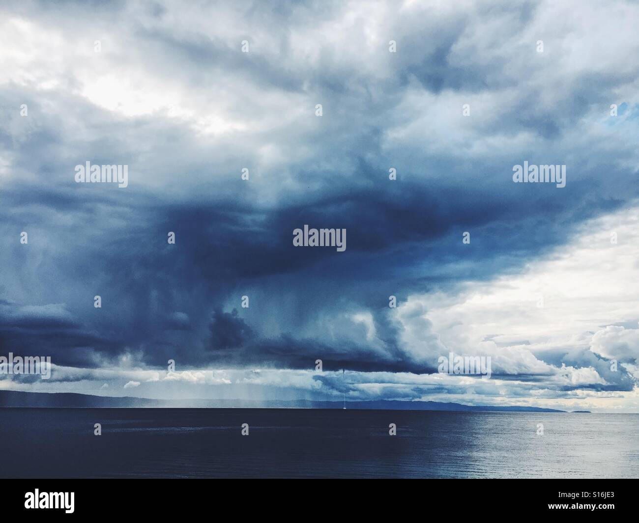 Rough stormy clouds over calm sea before storm Stock Photo - Alamy