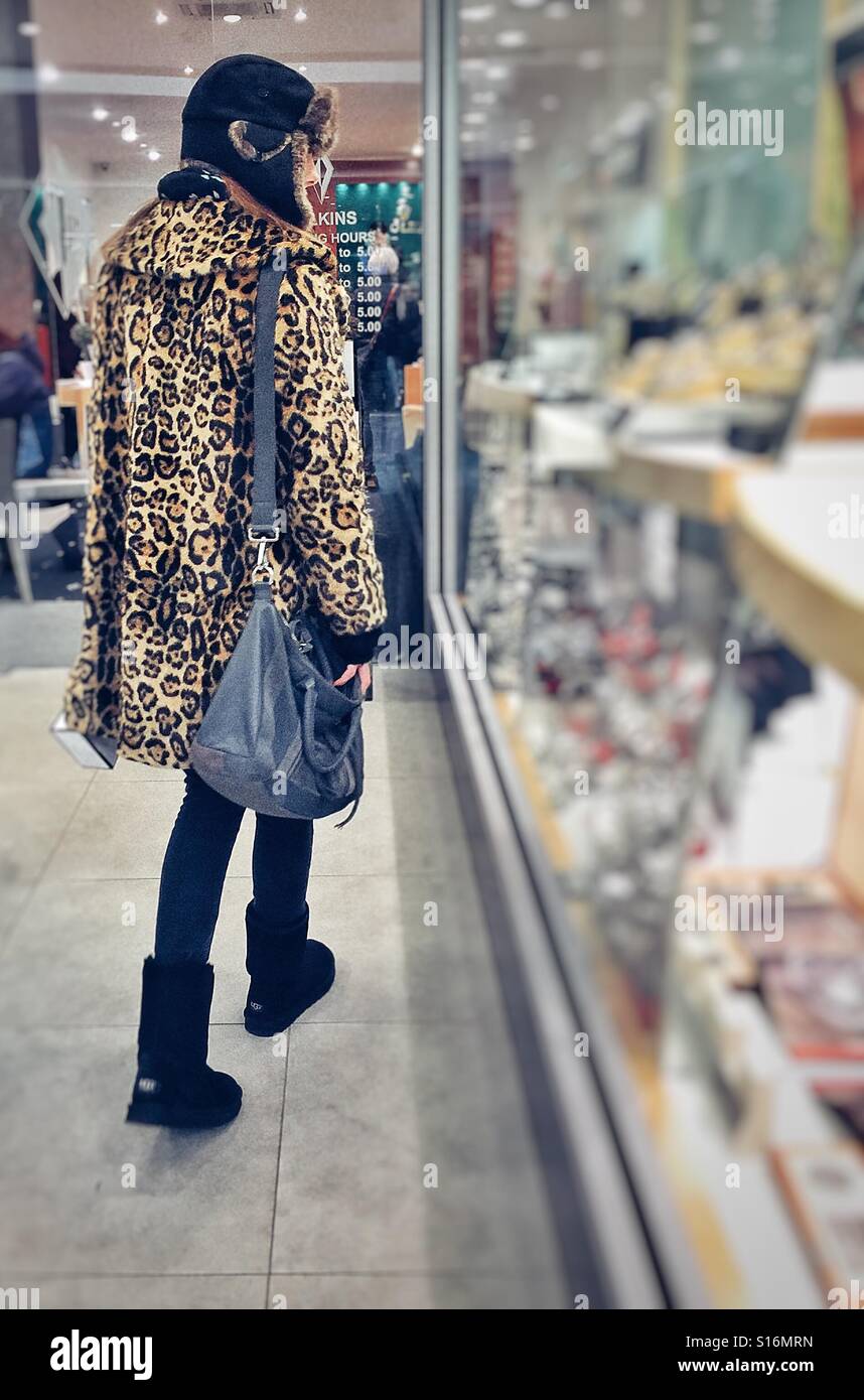 Woman with leopard coat window shopping Stock Photo - Alamy