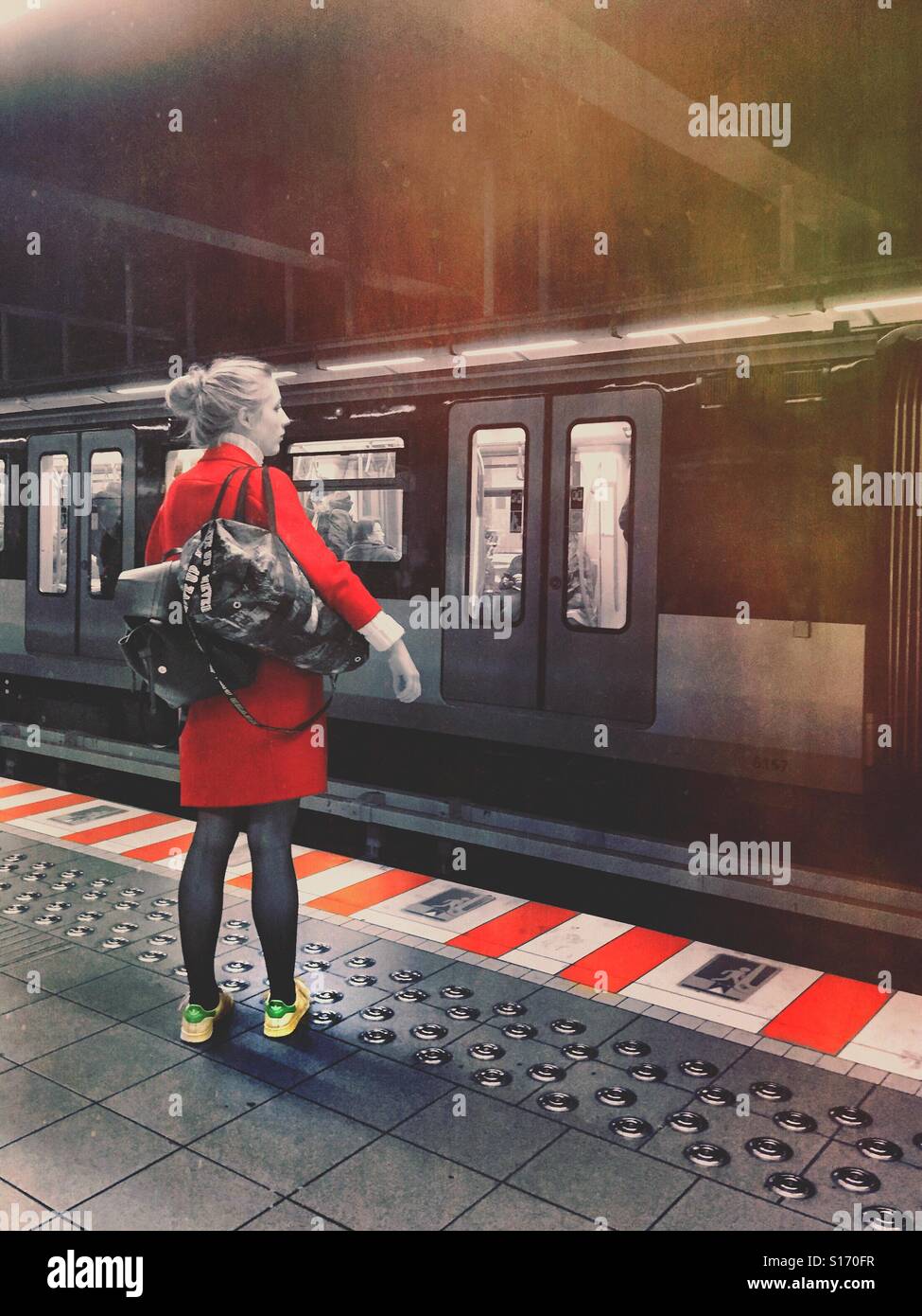 Woman in red waiting in the subway Stock Photo - Alamy