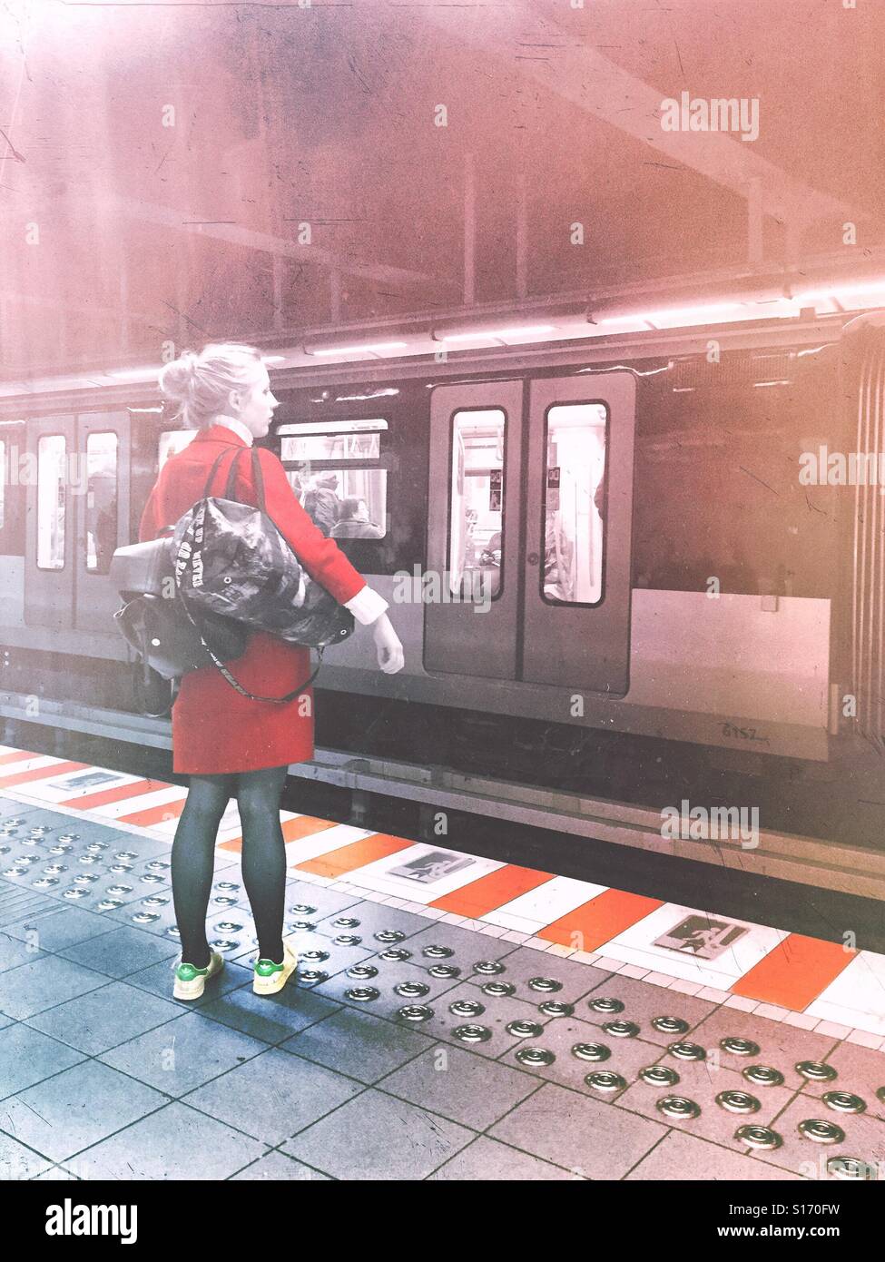 Woman in red waiting in the subway Stock Photo - Alamy