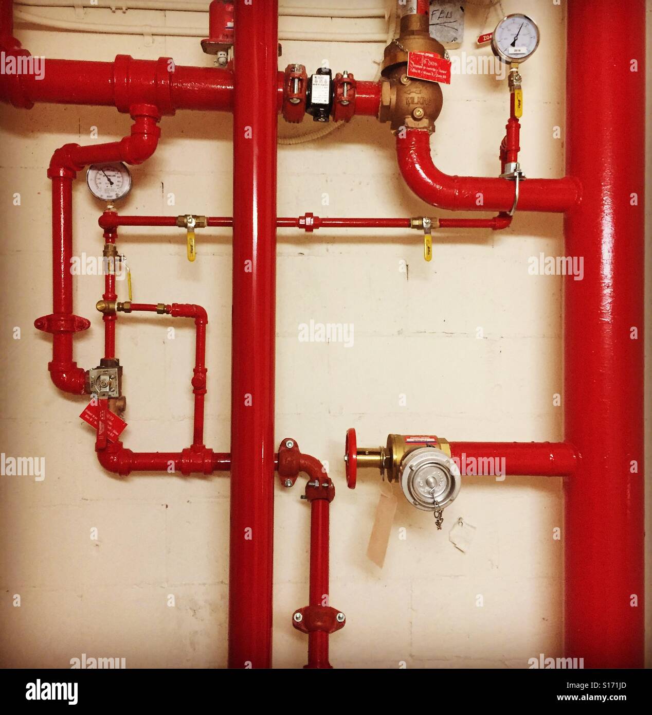 Red pipes on a concrete wall by K.R Stock Photo - Alamy
