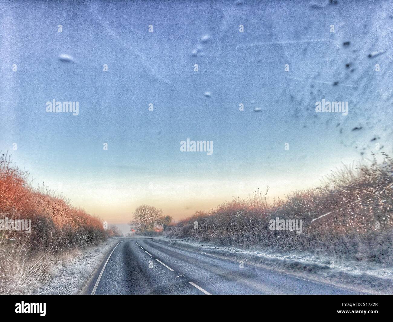 Driving in winter. Looking through the windscreen to an icy road and ...